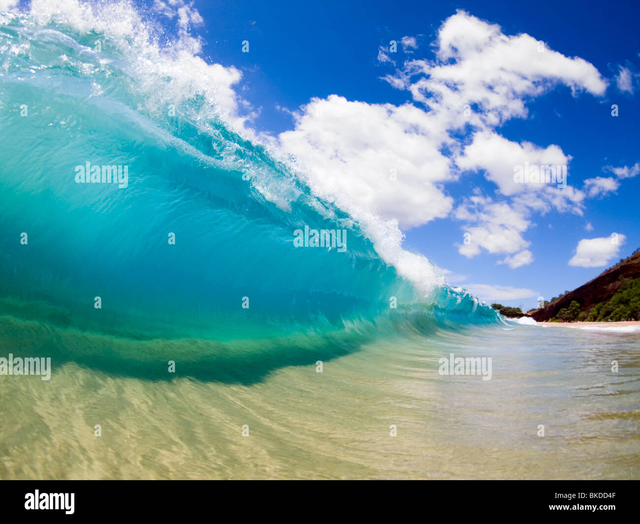 A powerful turquoise wave decides to hurl its force onto the sand in ...