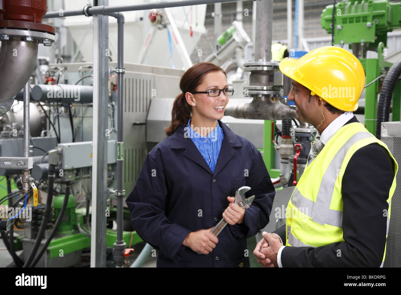Female industrial worker in meeting with Asian male factory manager ...