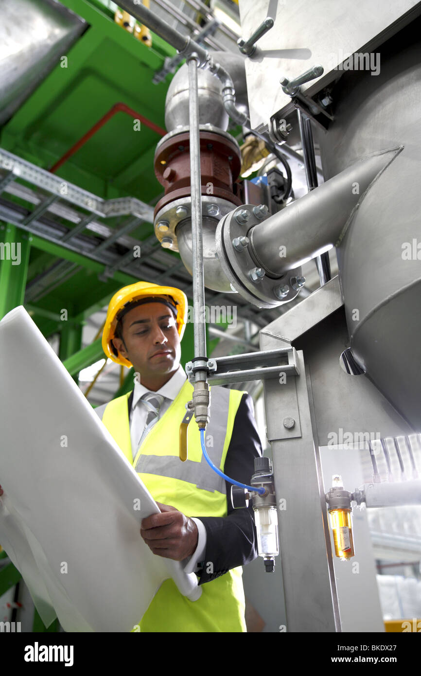 Asian factory manager wearing safety equipment checks machine Stock ...