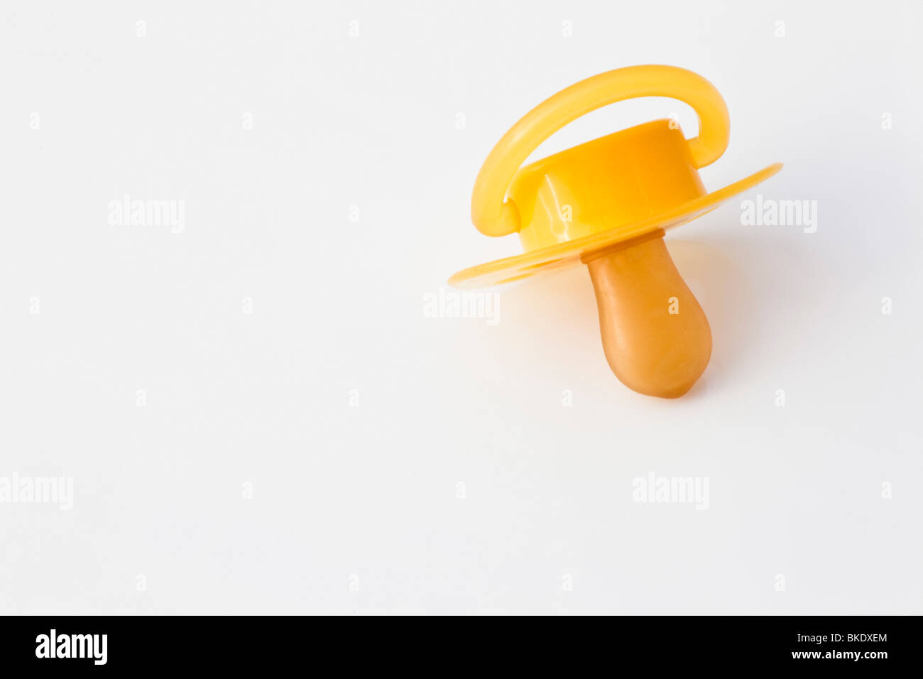 a colourful yellow children's dummy on a plain white backdrop Stock ...