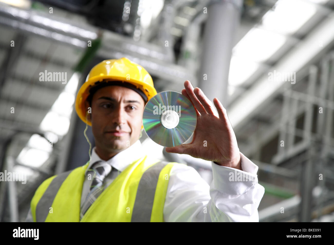 Factory manager looks at CD, viewed from distance Stock Photo - Alamy