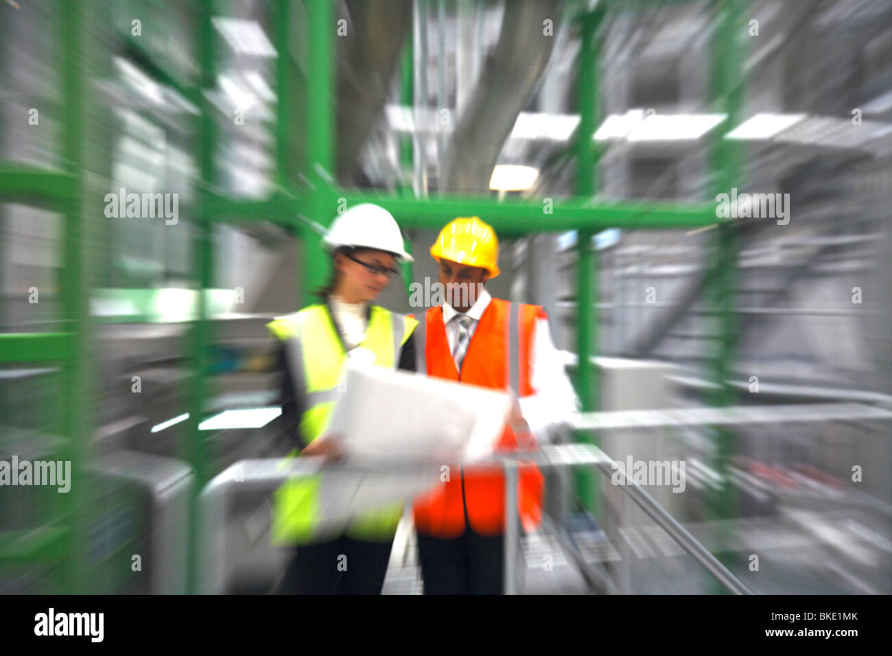 Female factory manager and asian male manager wearing safety equipment ...