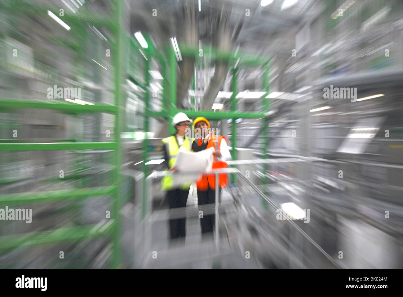 Female factory manager and asian male manager wearing safety equipment ...