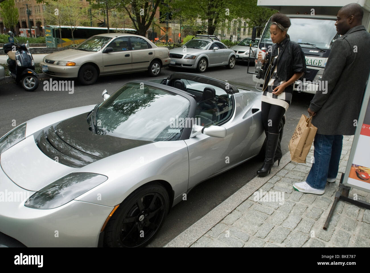 A couple looks at a Tesla Roadster outside an Earth Day event in New ...