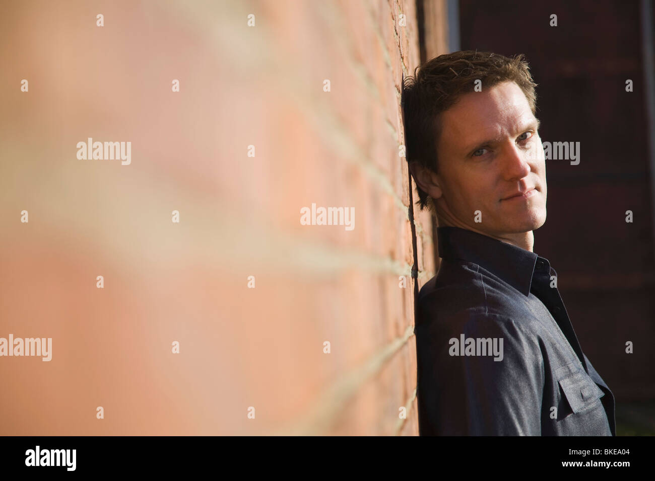 Man Leaning Against A Wall Stock Photo - Alamy