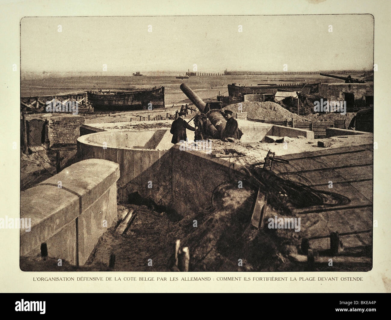 Soldiers with cannon at German fortification and bunkers on beach at ...