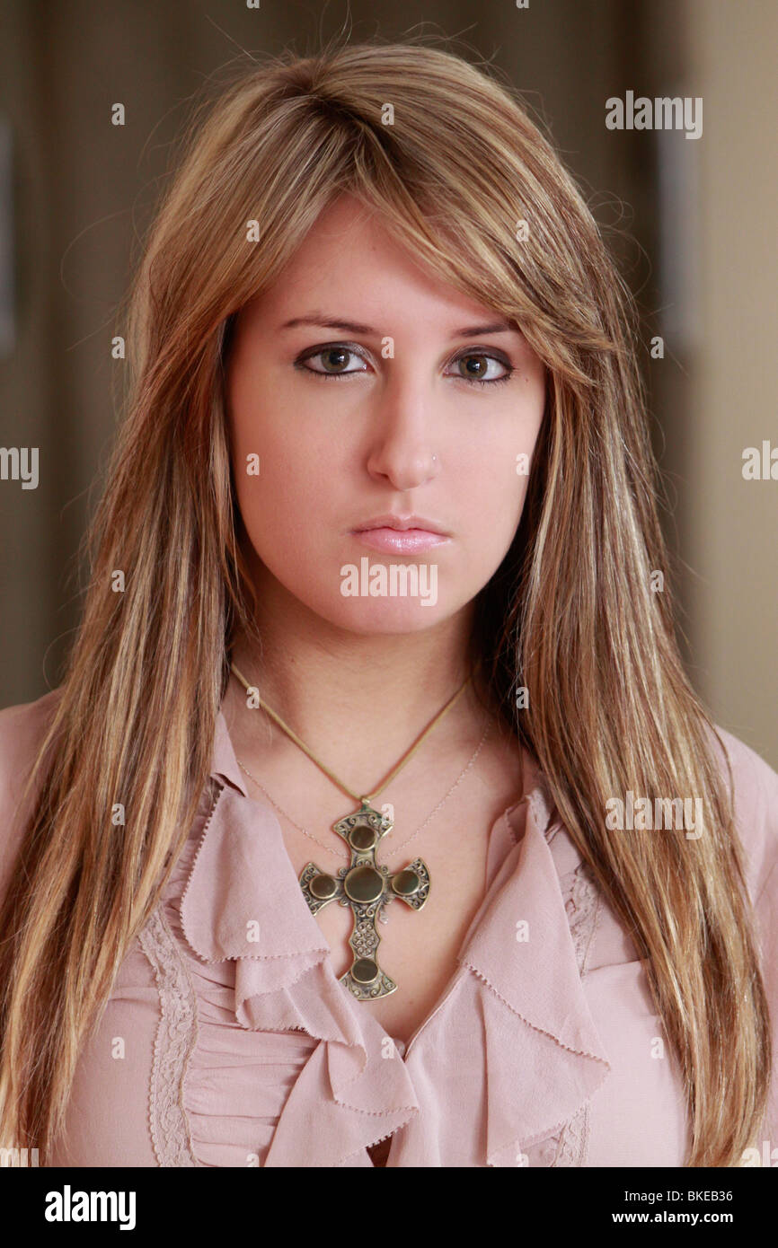 pretty girl wearing cross long hair serious Stock Photo - Alamy
