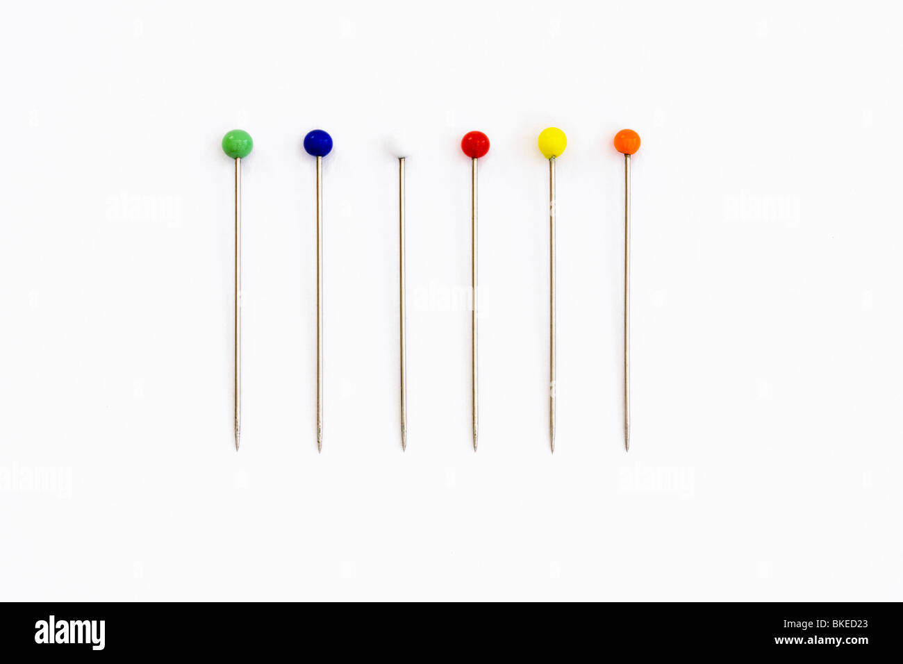 a line of sewing pins on a white background Stock Photo - Alamy