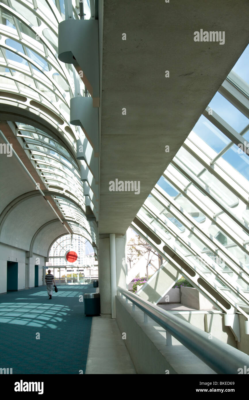 Man walking down hallway with curved glass ceiling in San Diego ...