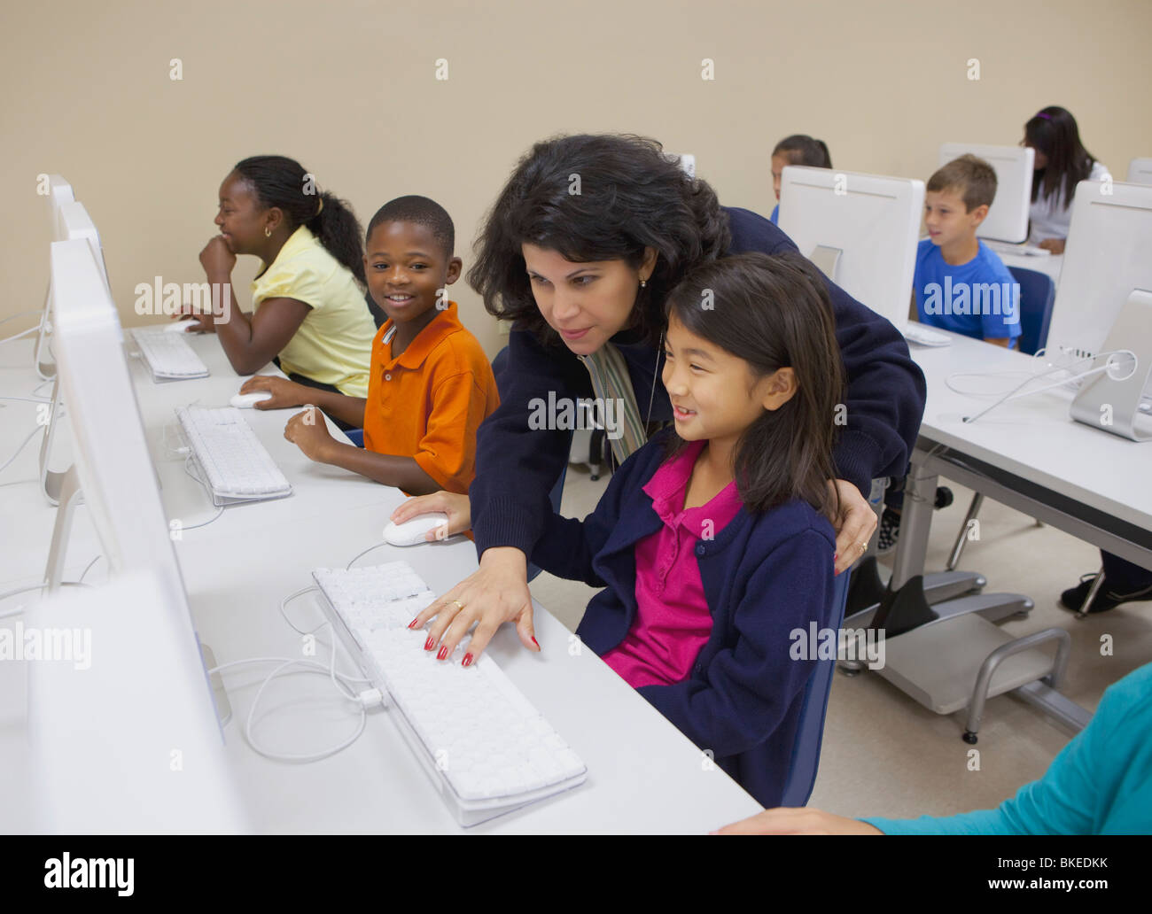 Teacher Working With Students In Computer Class Stock Photo - Alamy