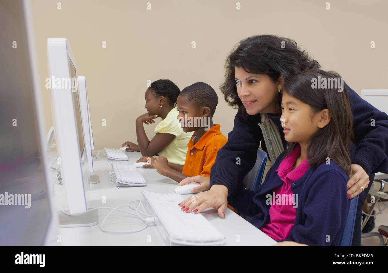 Teacher Helping Student On The Computer Stock Photo - Alamy