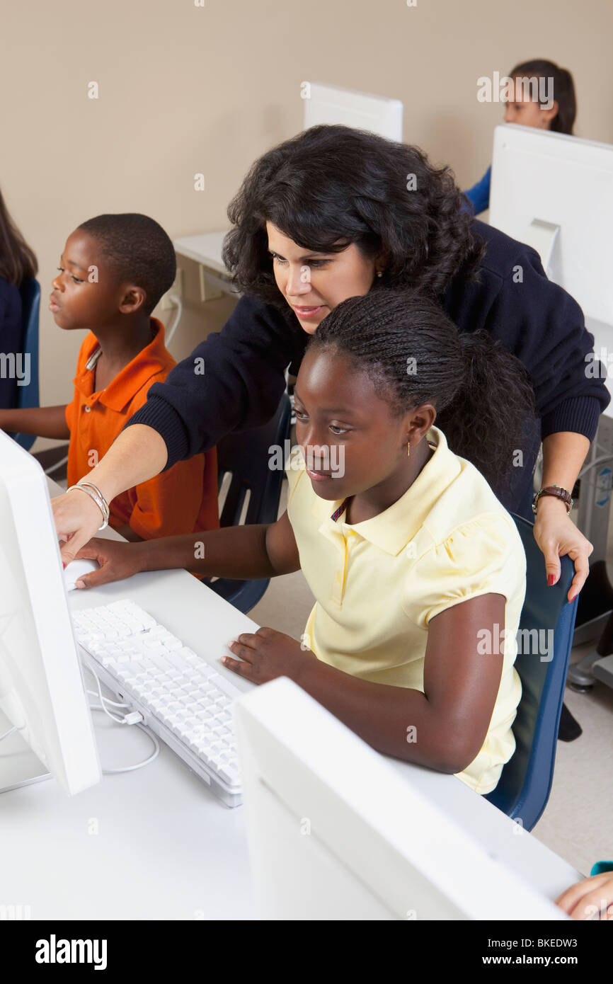 Teacher Helping Students In Computer Class Stock Photo - Alamy