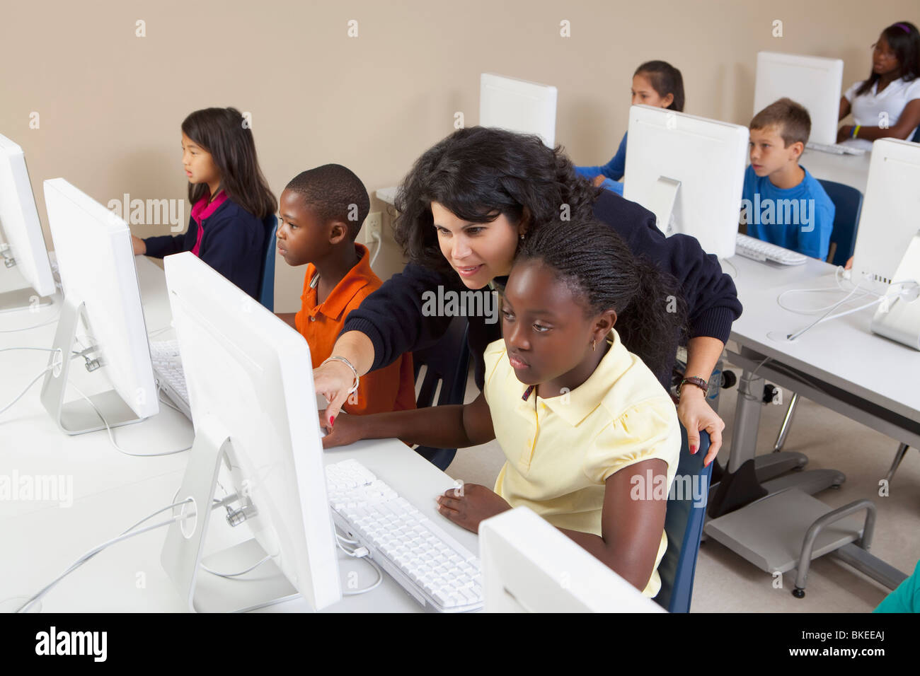 Teacher Helping Students In Computer Class Stock Photo - Alamy