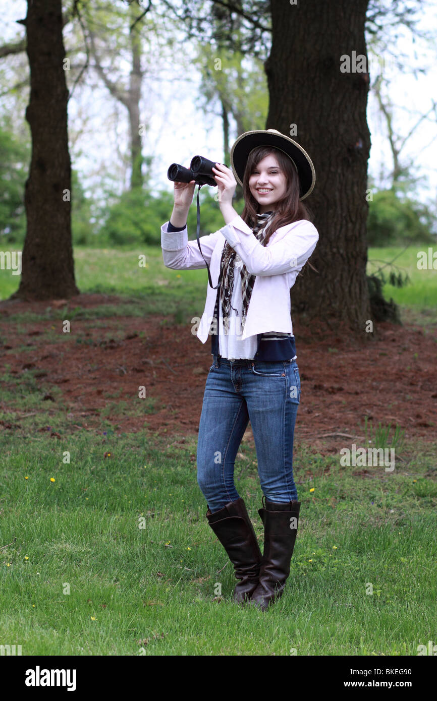 beautiful young lady in the country looking at and studying birds and ...