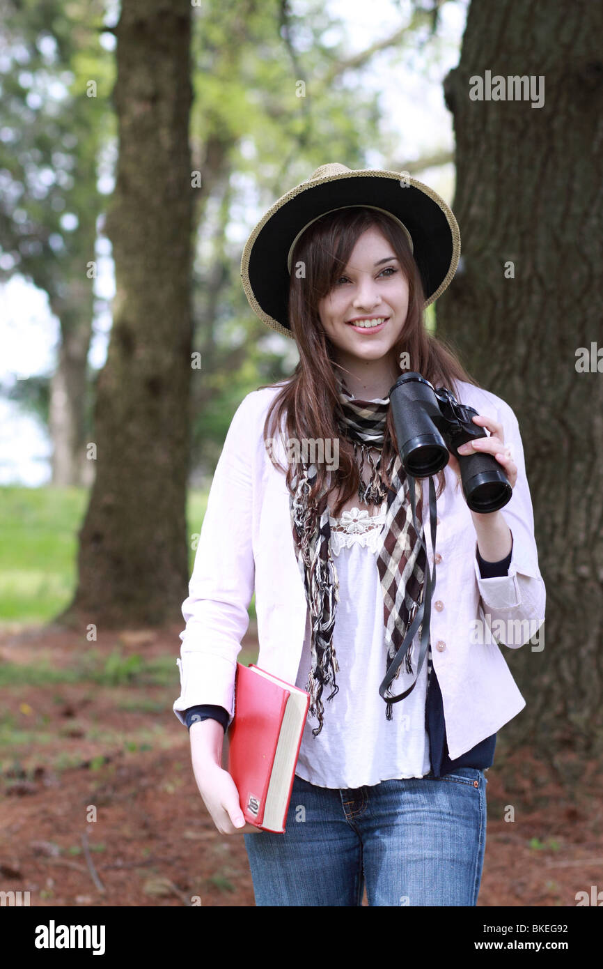 beautiful young lady in the country looking at and studying birds and ...