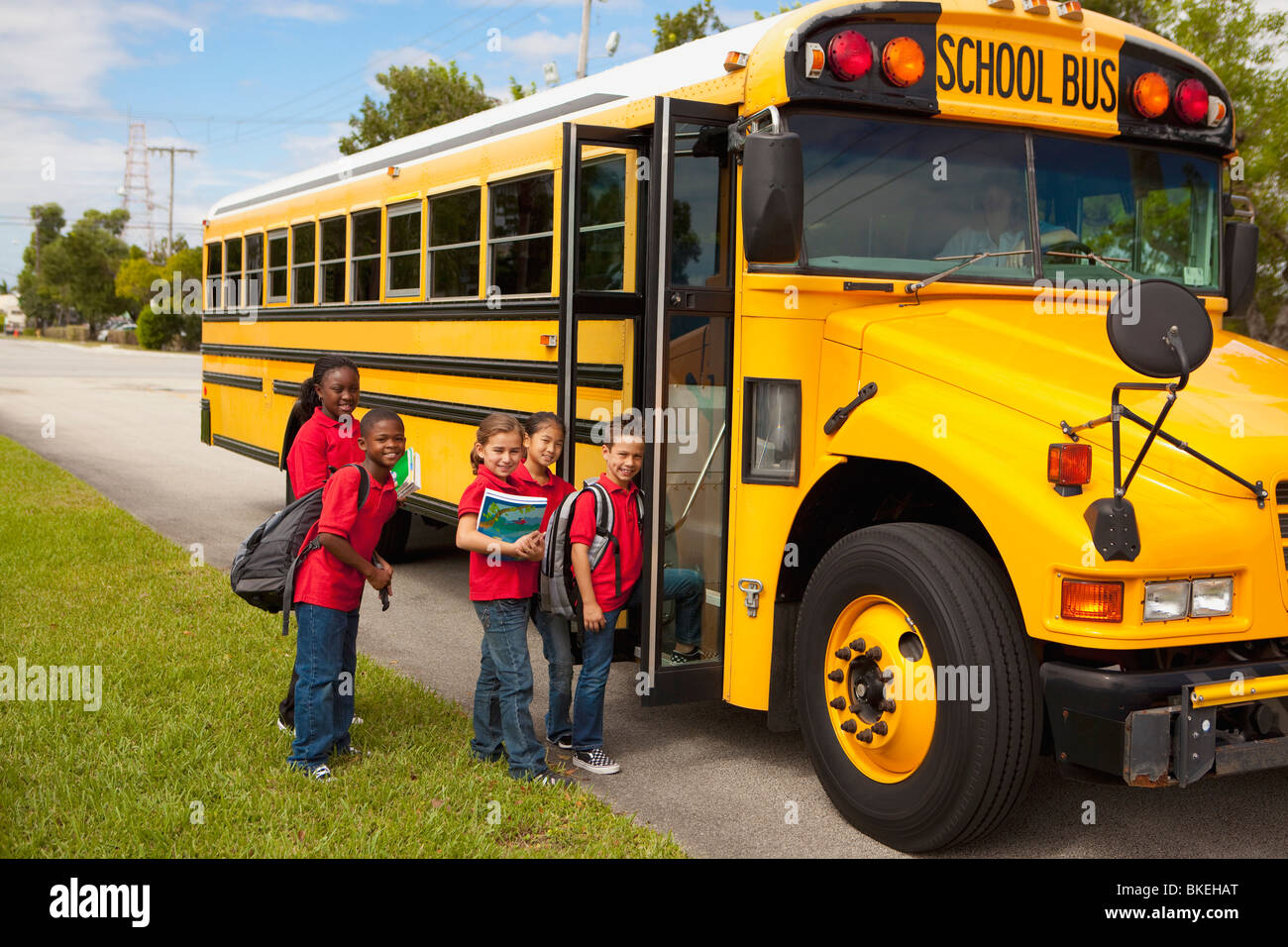 Students Lining Up To Get On The School Bus Stock Photo - Alamy