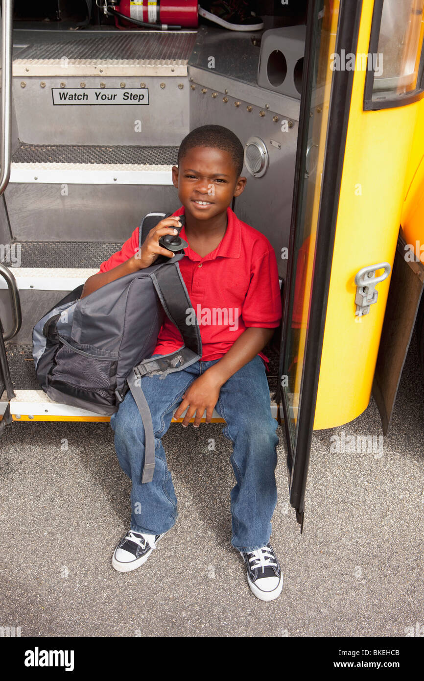 Student Sitting On The Step Of The School Bus Stock Photo - Alamy
