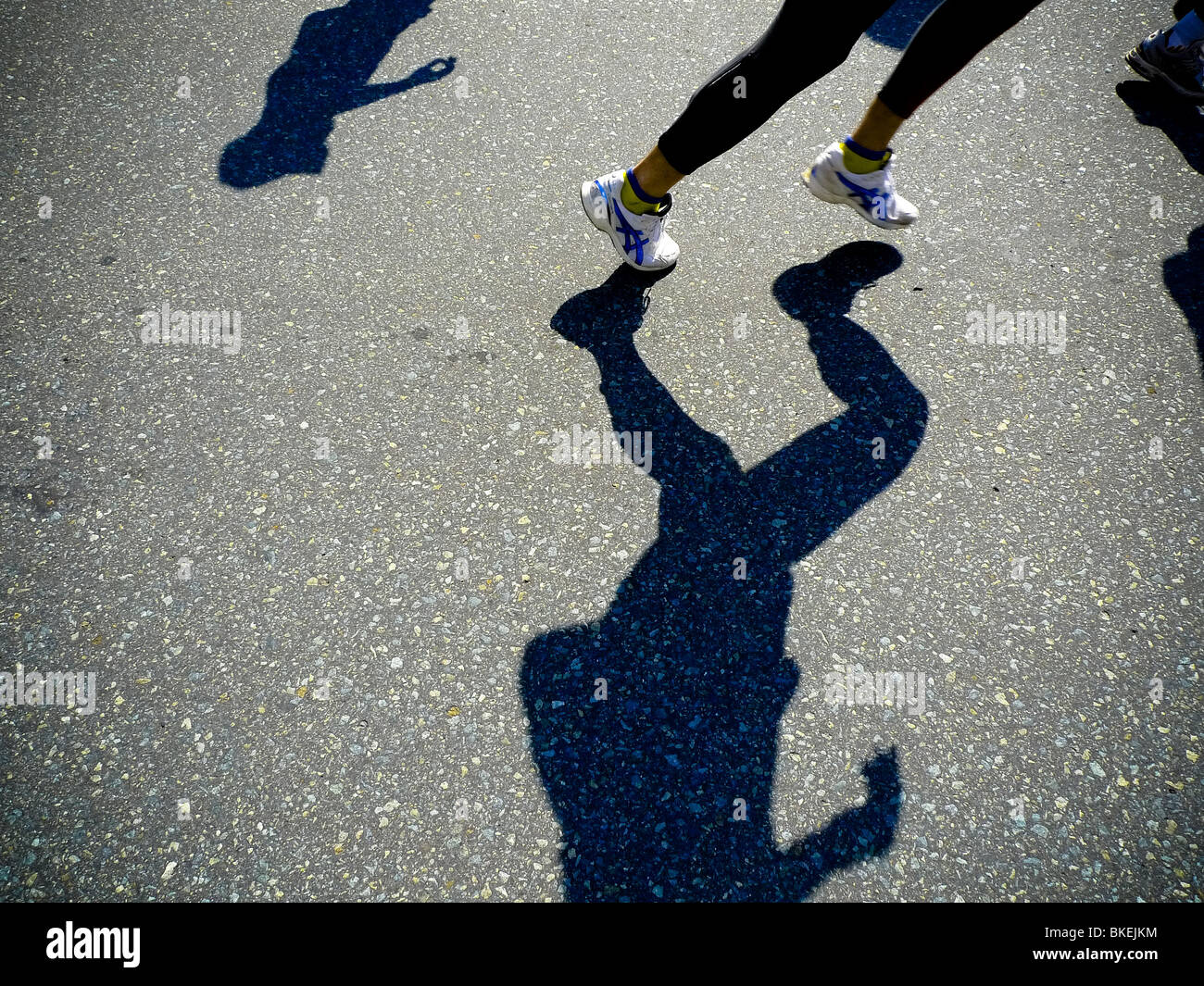 Shadows of runner's legs whilst competing in marathon road race Stock ...