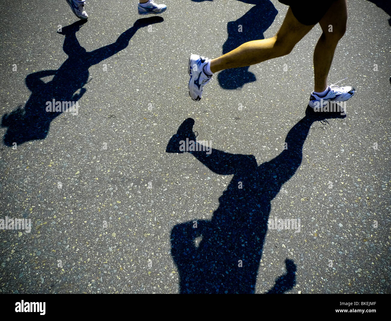 Shadows of runner's legs whilst competing in marathon road race Stock ...