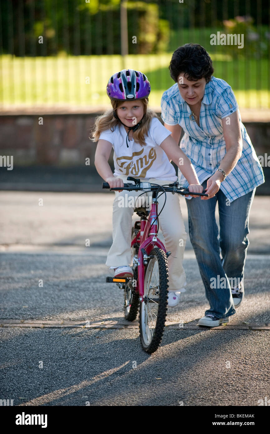 Young girl learning to ride bike with mum FULLY MODEL RELEASED Stock ...