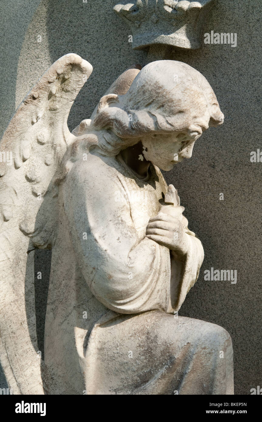 Statue of a genuflecting angel in a servile position, part of a ...