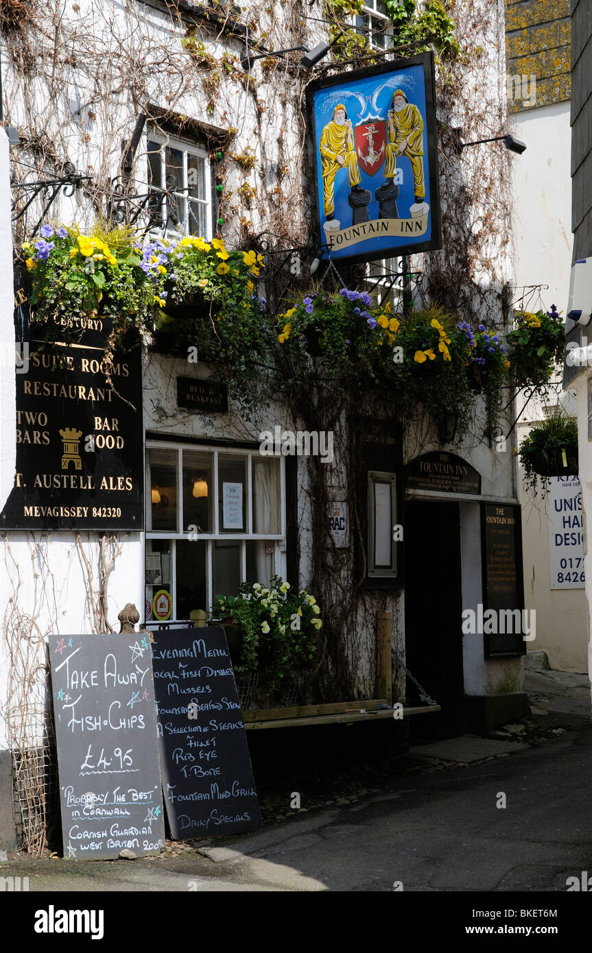 Exterior of an English pub decorated with flowers and advertising ...