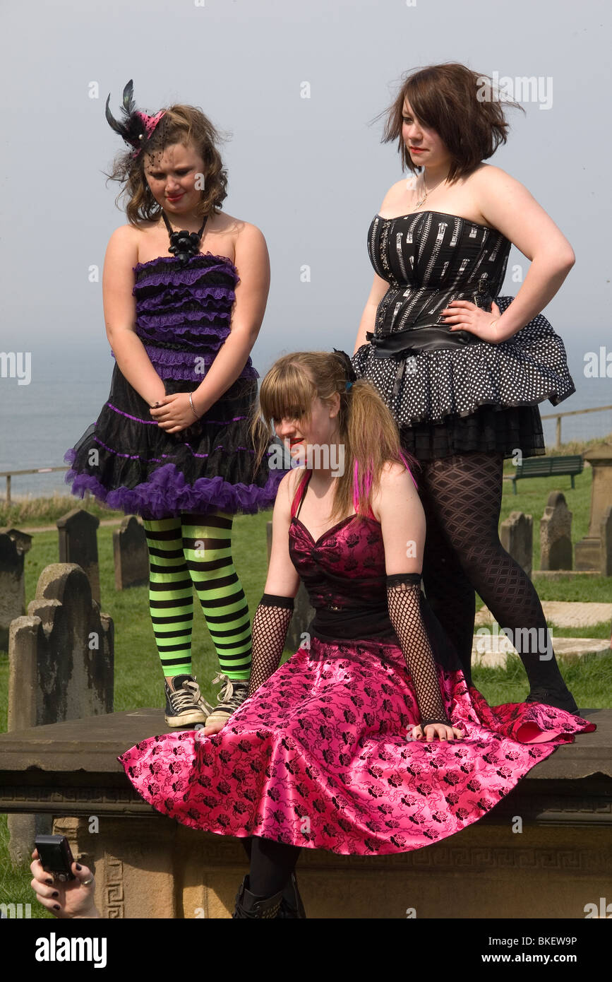 Three teenage girls in fancy dress pose on a grave in St Mary's ...