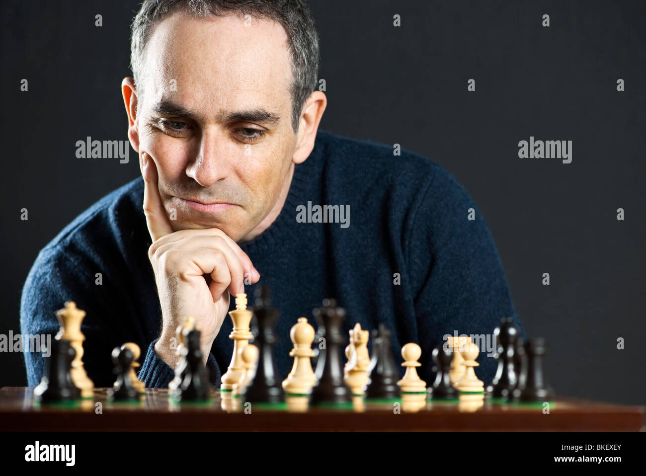 Chessboard with man thinking about chess strategy Stock Photo - Alamy