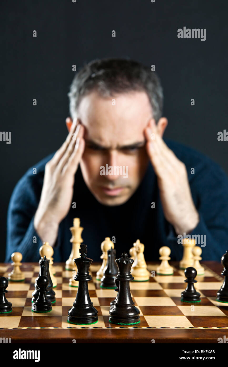 Chessboard with man thinking about chess strategy Stock Photo - Alamy