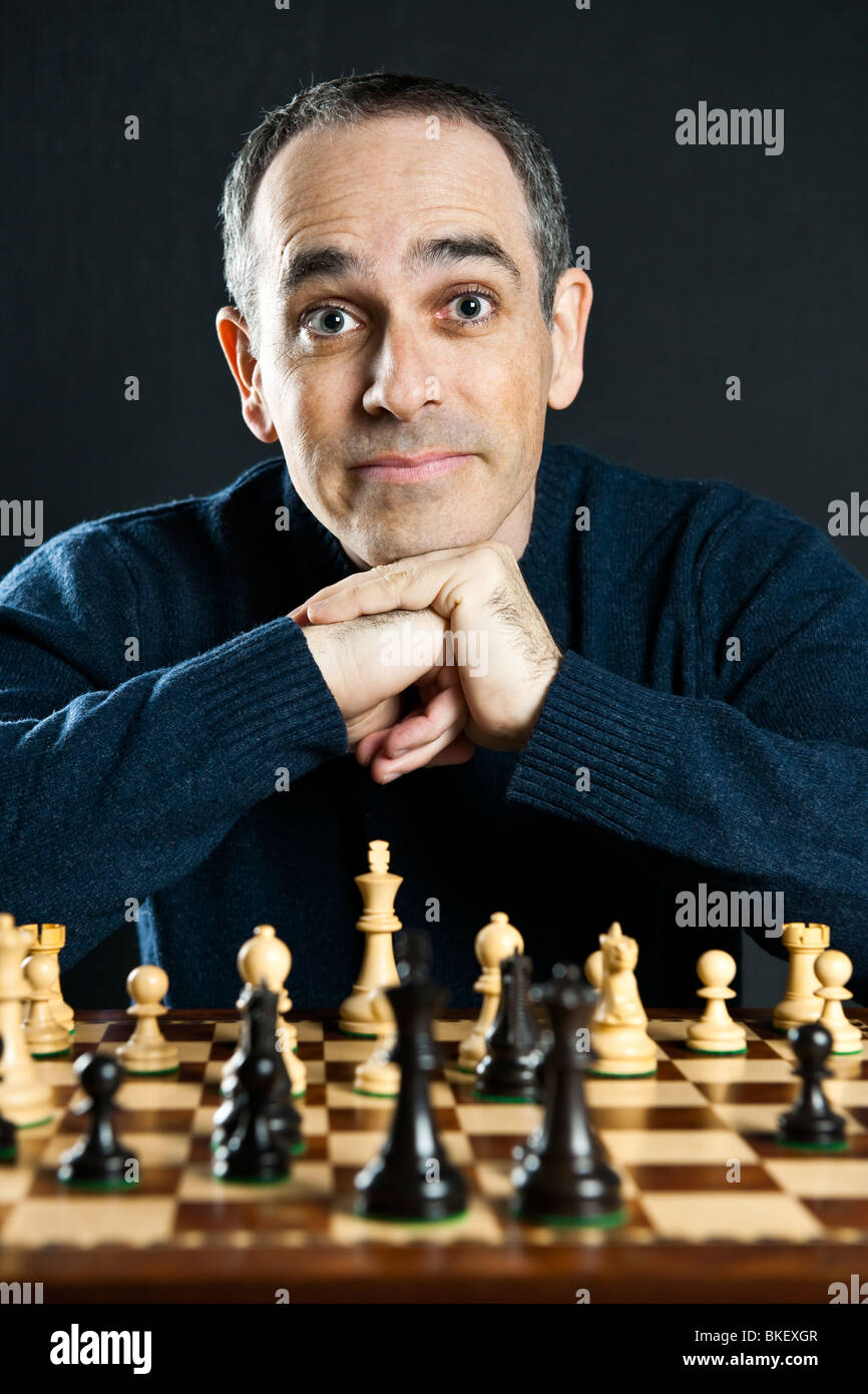 Chessboard with man thinking about chess strategy Stock Photo - Alamy