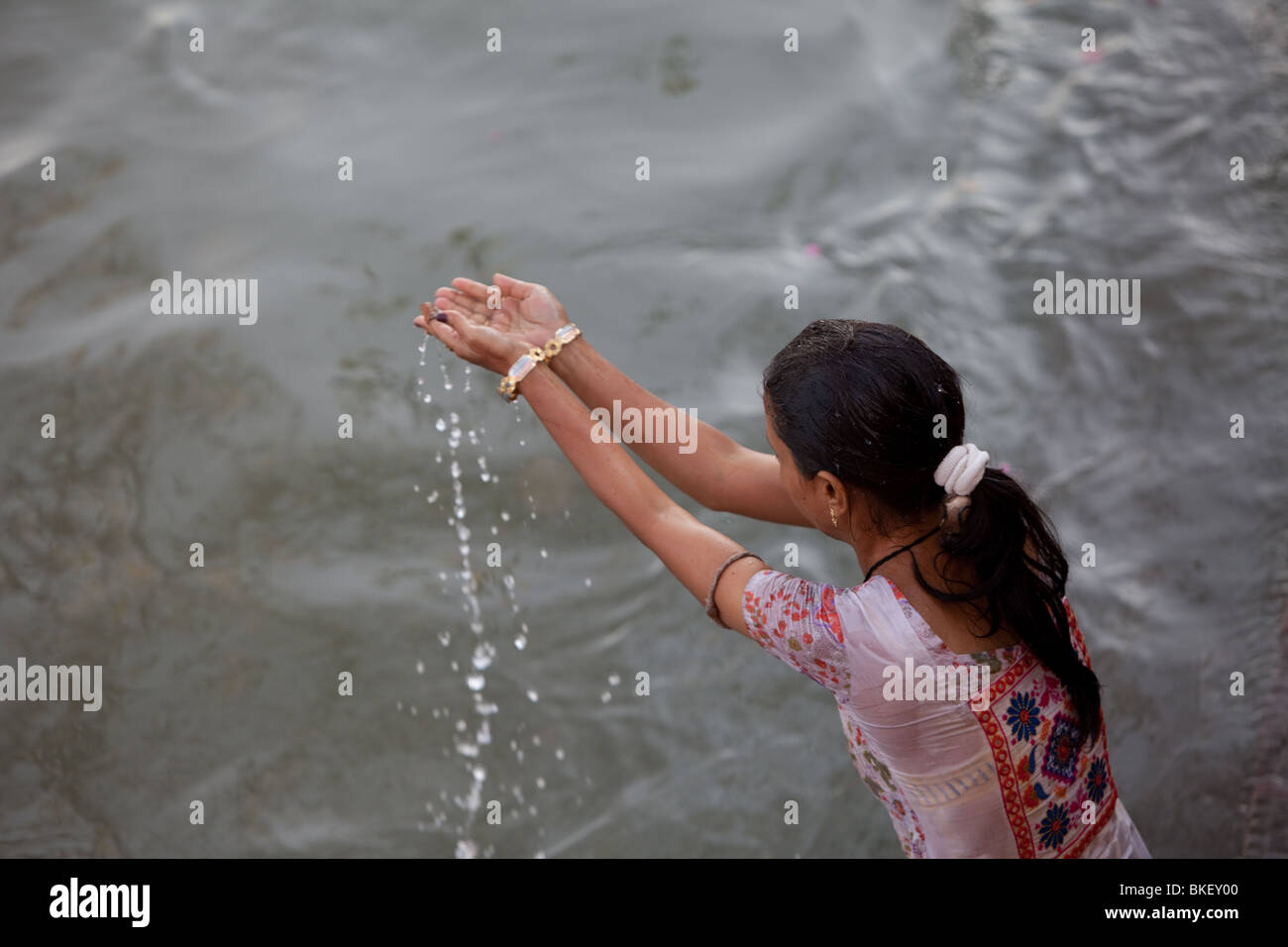Young woman making an offering to the sun of the Ganges water Stock ...