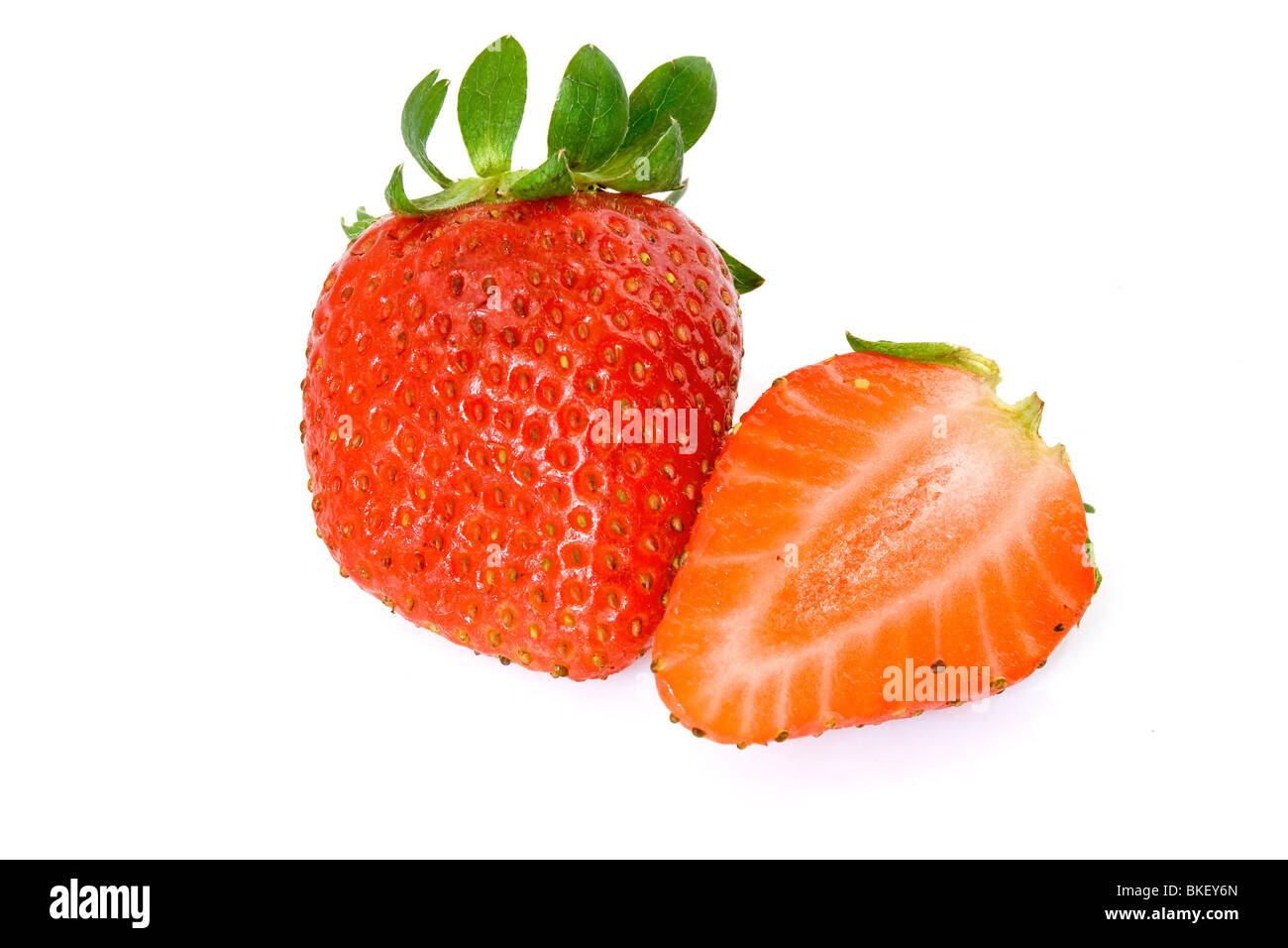 two strawberries, one cut in half, isolated on white background with ...