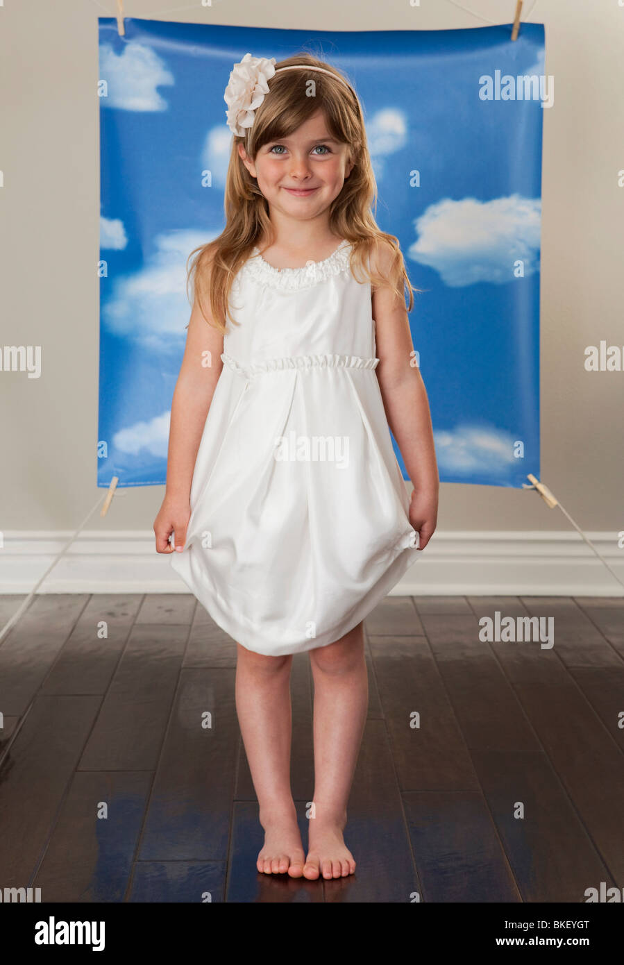 Girl in sundress in fron of blue sky backdrop Stock Photo - Alamy