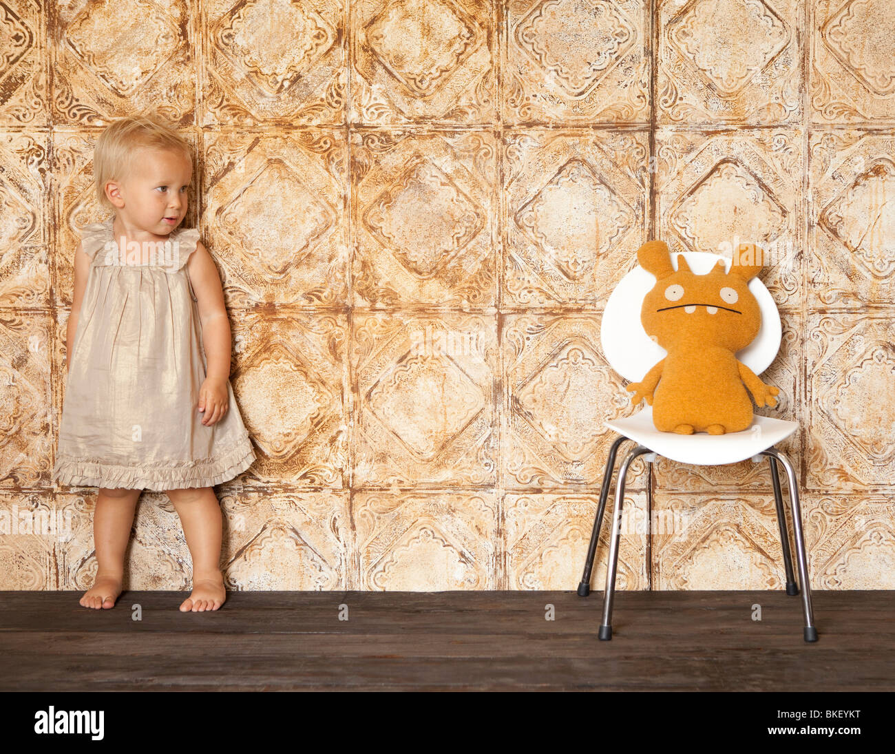 Little girl scared of stuffed animal on chair Stock Photo - Alamy