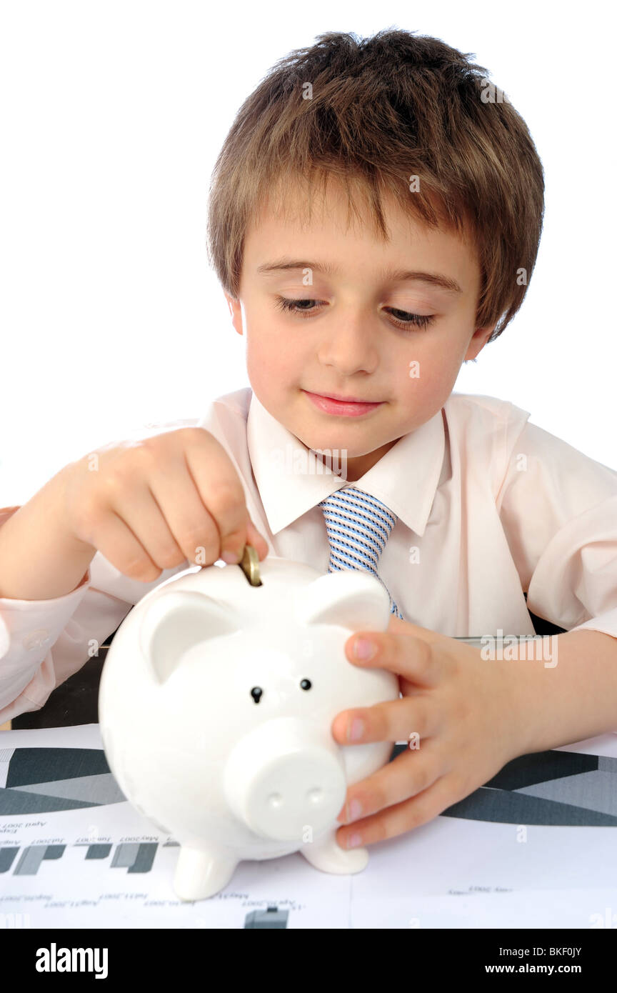 Vertical image of a young boy putting money into his piggy bank Stock ...