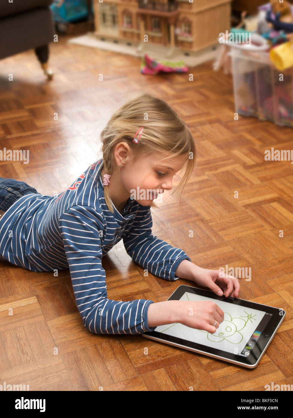 Child on living room floor playing with Apple iPad touchscreen computer ...