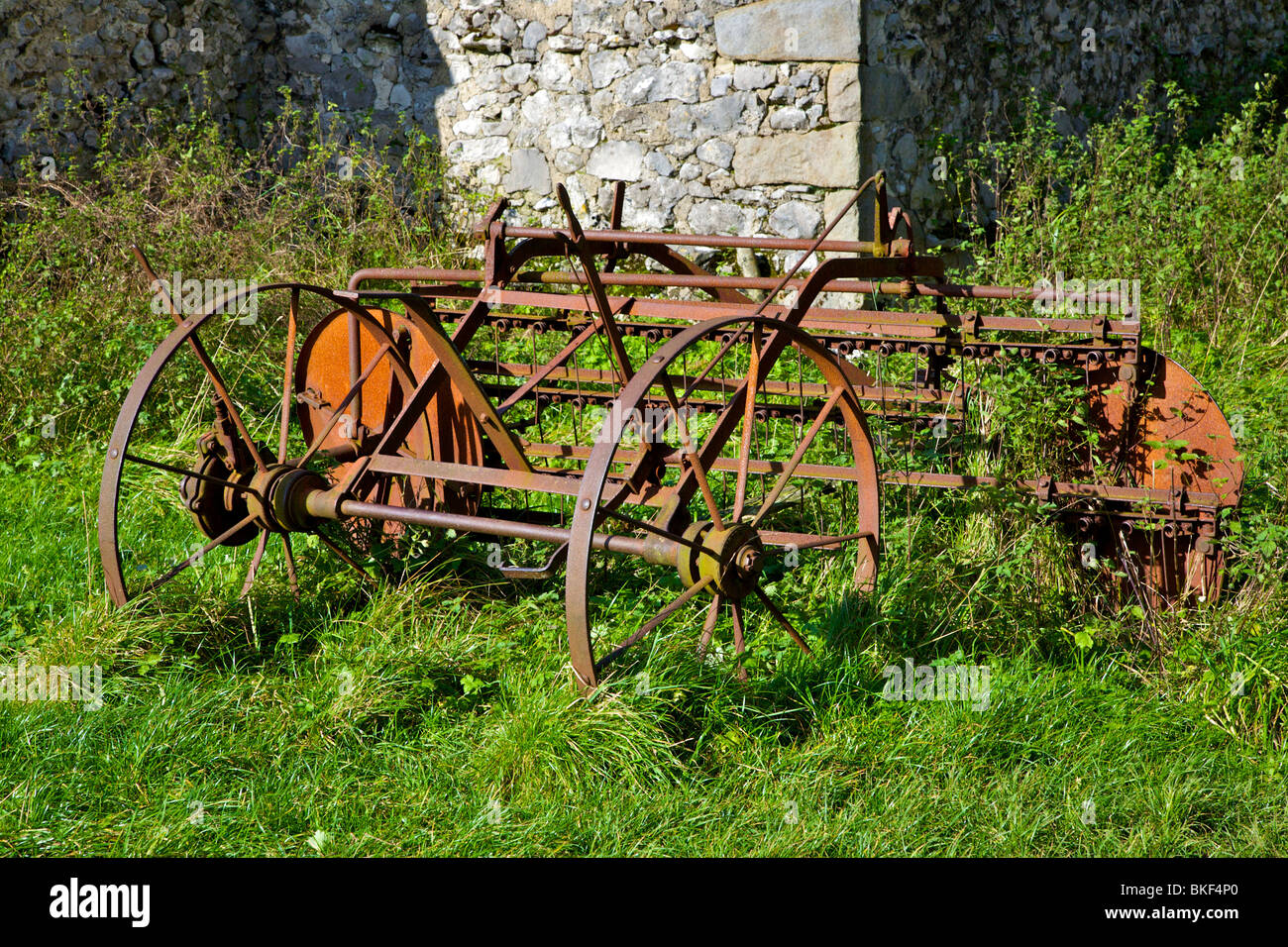 rusty farm machinery in corner of field Stock Photo - Alamy