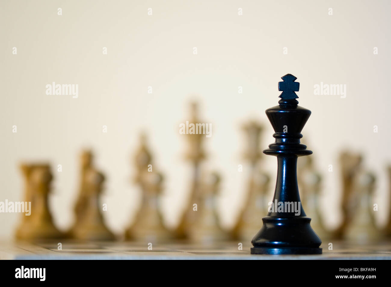 Chess, black King in front of white chess pieces on chess board Stock ...