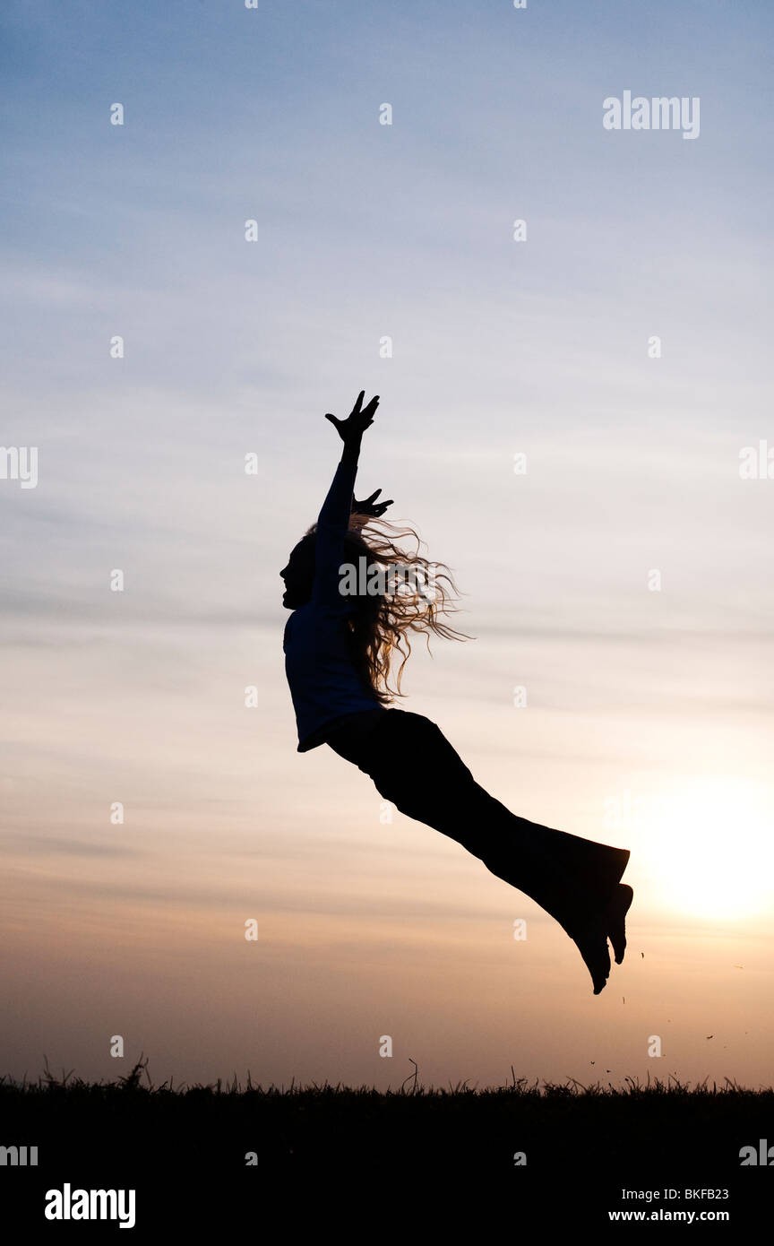 Young Girl energetically having fun jumping around. Silhouette Stock ...