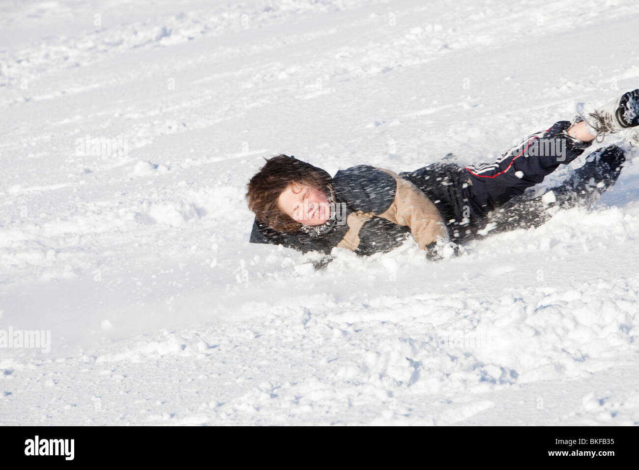 A young boy falling over in the snow, UK Stock Photo - Alamy