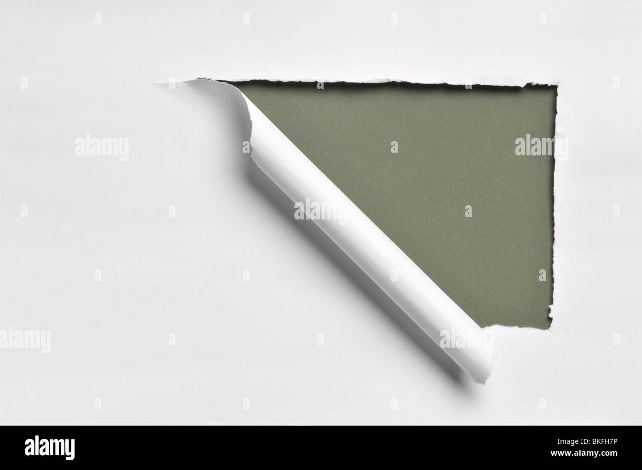ripped white paper against a green background Stock Photo - Alamy