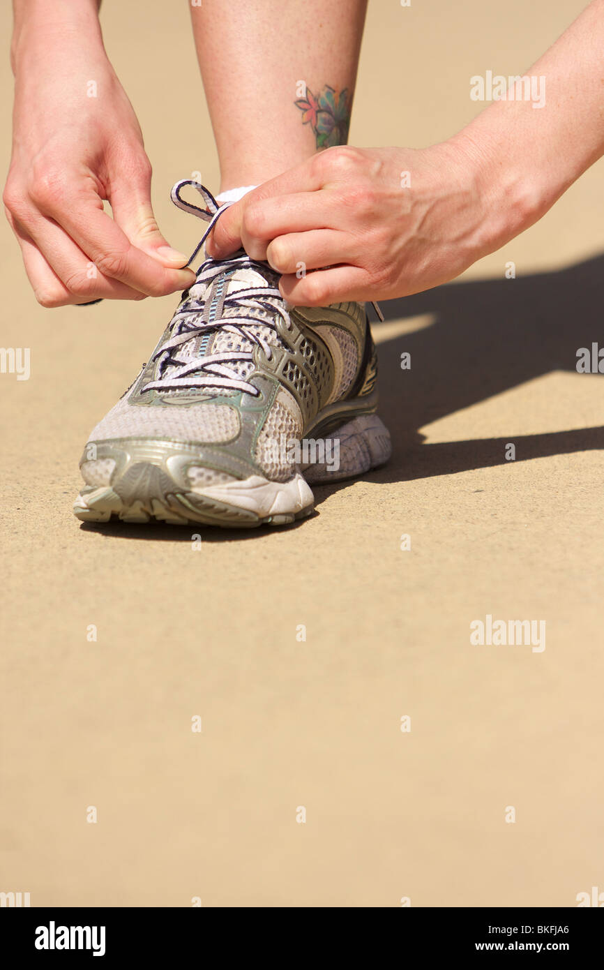Female runner tying shoe Stock Photo - Alamy