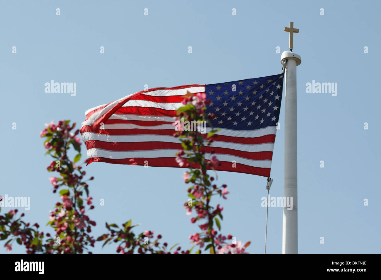 The Catholic church with a cross and US flag on a flagpole with ...