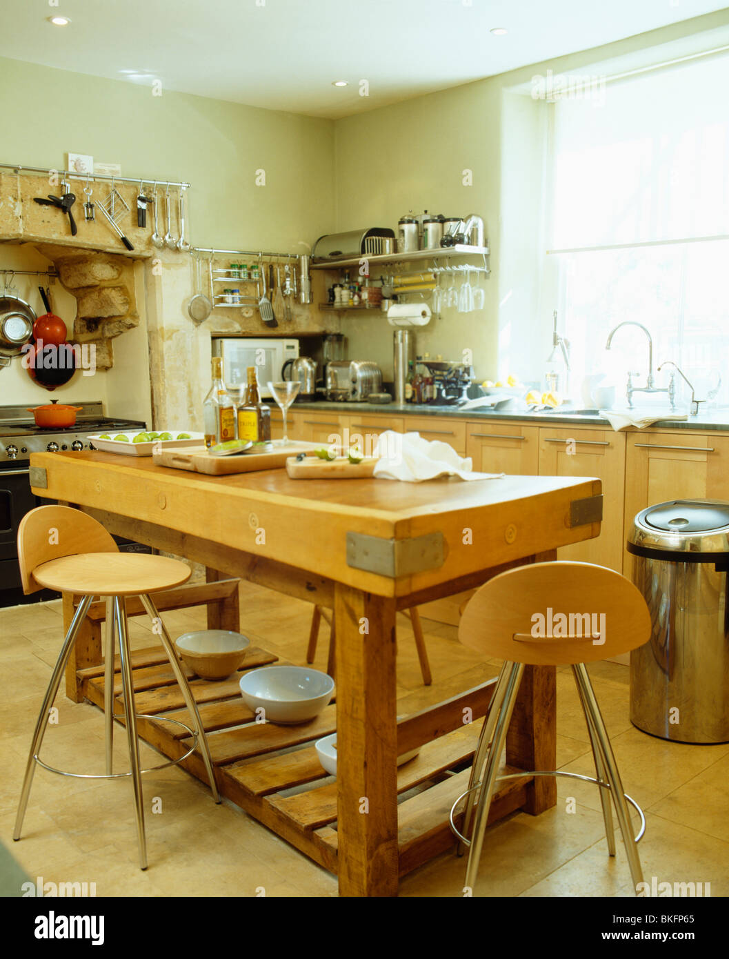 Wood and steel stools at butcher's block in modern kitchen Stock Photo ...