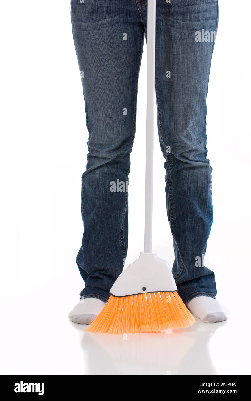 Young woman holding a modern broom with orange bristles Stock Photo - Alamy