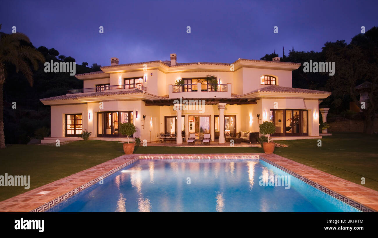 Swimming pool with underwater lighting in front of large Spanish villa ...