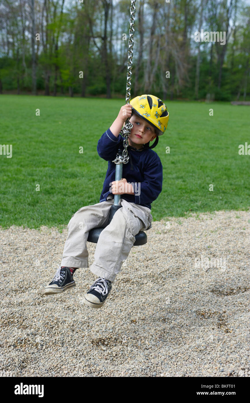 A young child boy riding a toy rope way playground summer Stock Photo ...