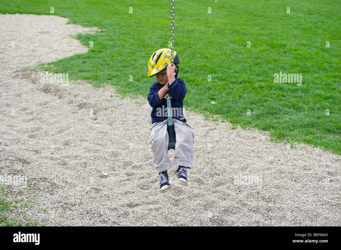 A young child boy riding a toy rope way playground summer Stock Photo ...