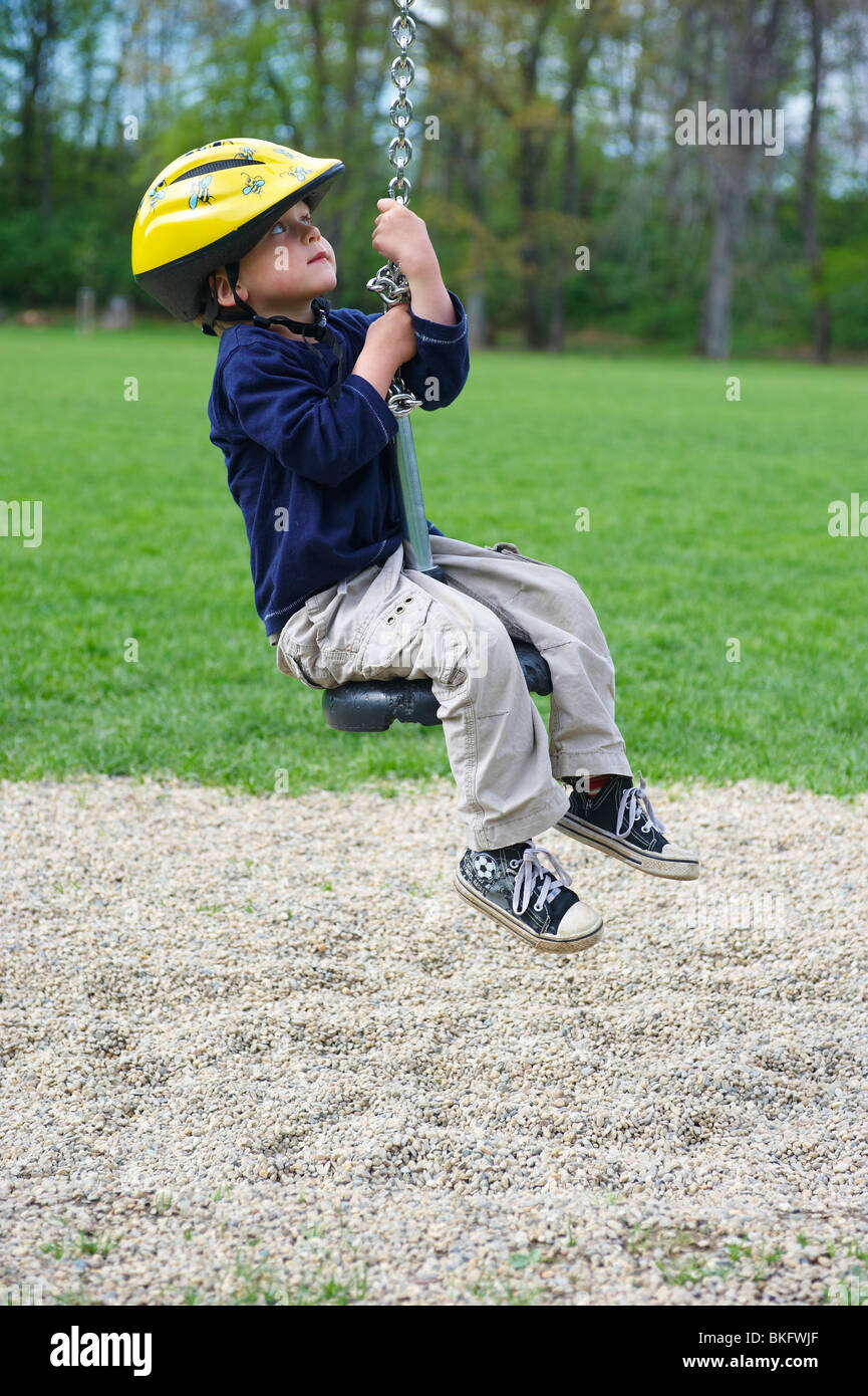 A young child boy riding a toy rope way playground summer Stock Photo ...