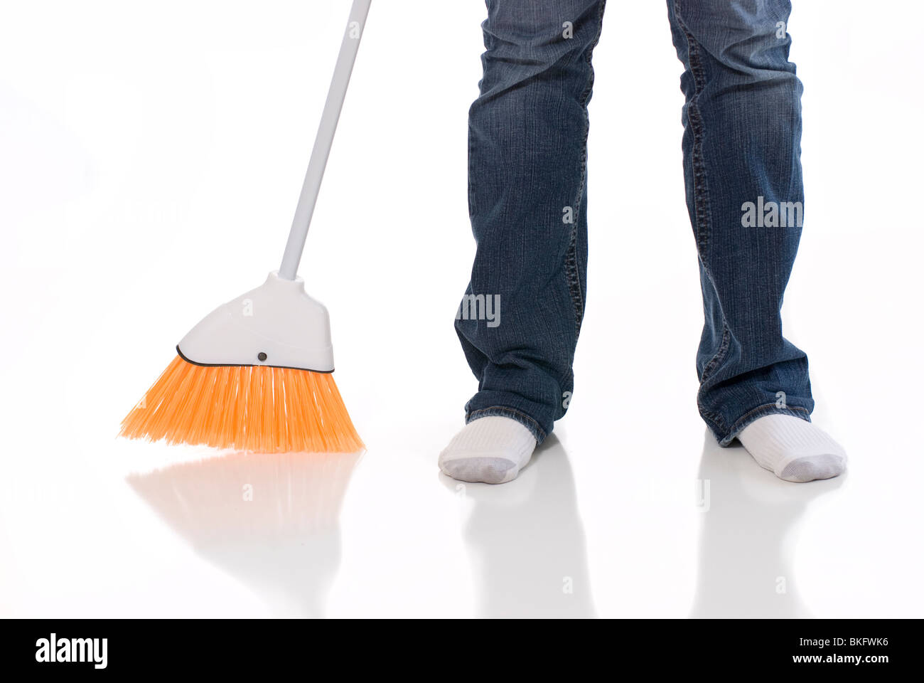 Young woman holding a modern broom with orange bristles Stock Photo - Alamy